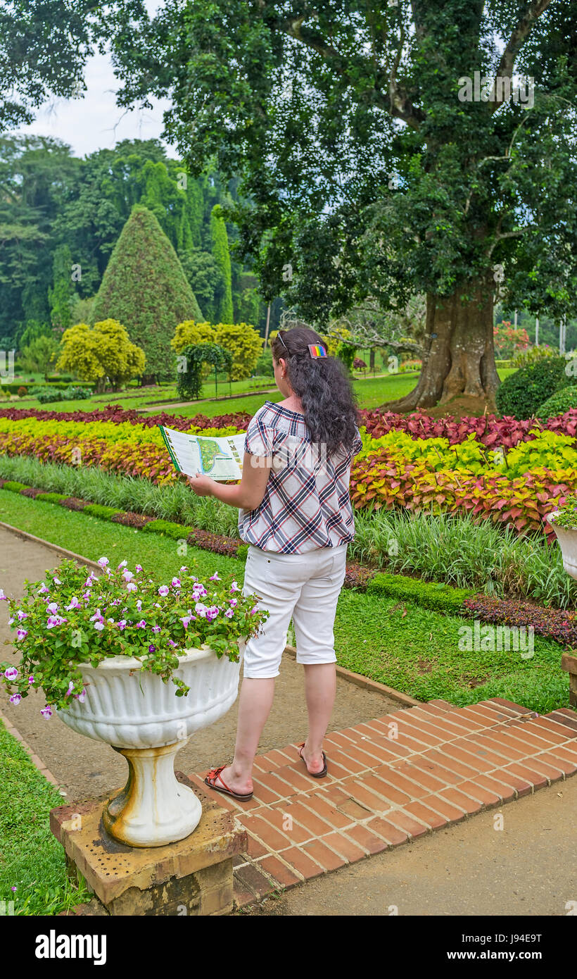 KANDY, SRI LANKA - NOVEMBER 28, 2016: The girl with a map of Peradeniya ...