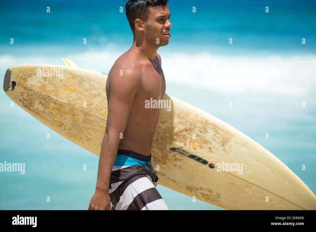 RIO DE JANEIRO - FEBRUARY 6, 2017: Young Brazilian surfer walks with ...