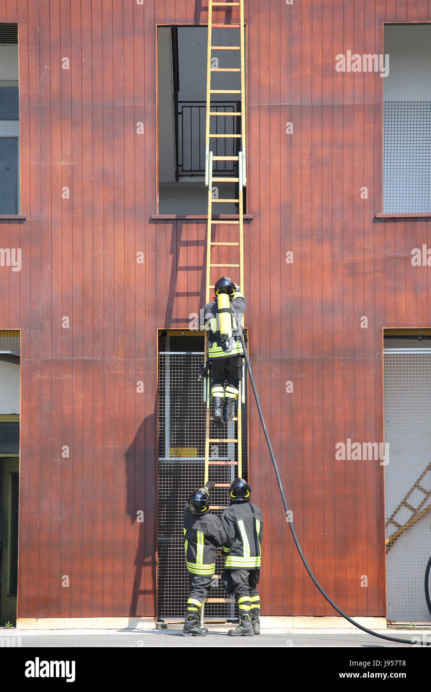 Intrepid firefighters on the wooden ladder during firefighting in the ...