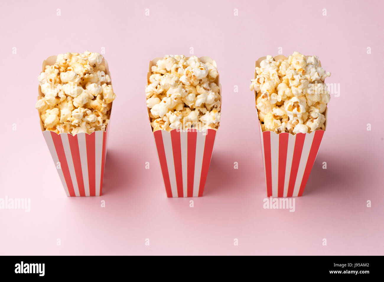 Popcorn in red and white cardboard box on the pink background Stock ...