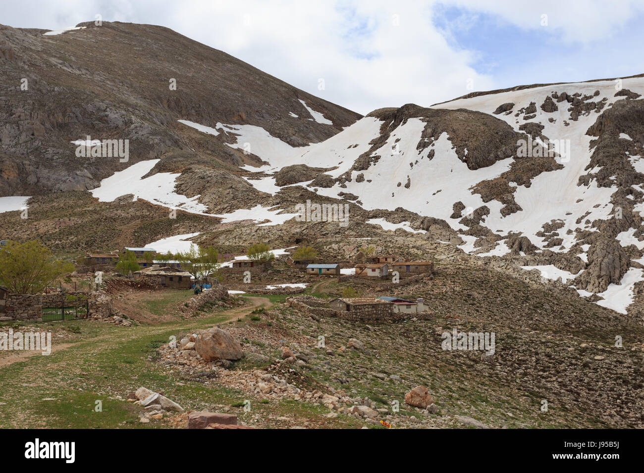 Mountain landscape with slopes covered by melting snow and small ...