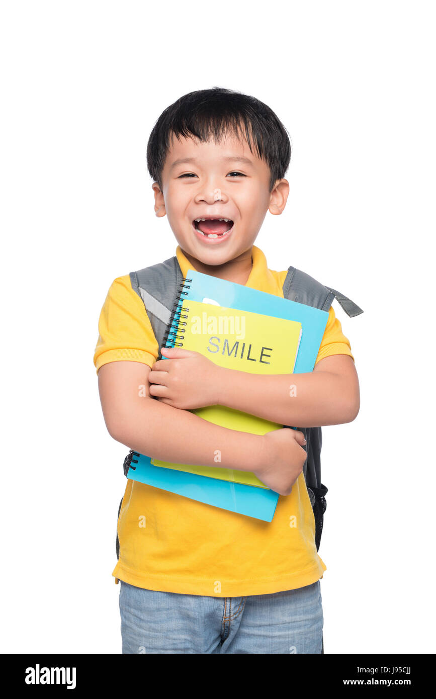 Portrait of cute smiling boy with backpack and colorful books ...