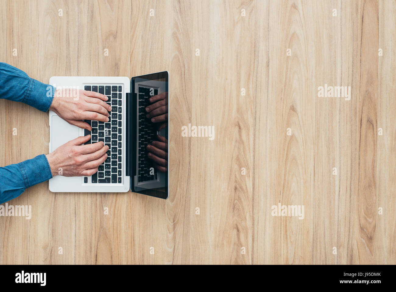 Man sitting at desk and working with a computer, he is typing and ...