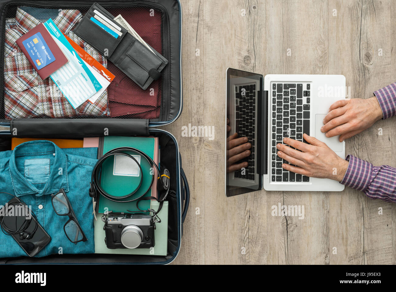 Traveler getting ready to leave and packing his bag, he is typing on a ...