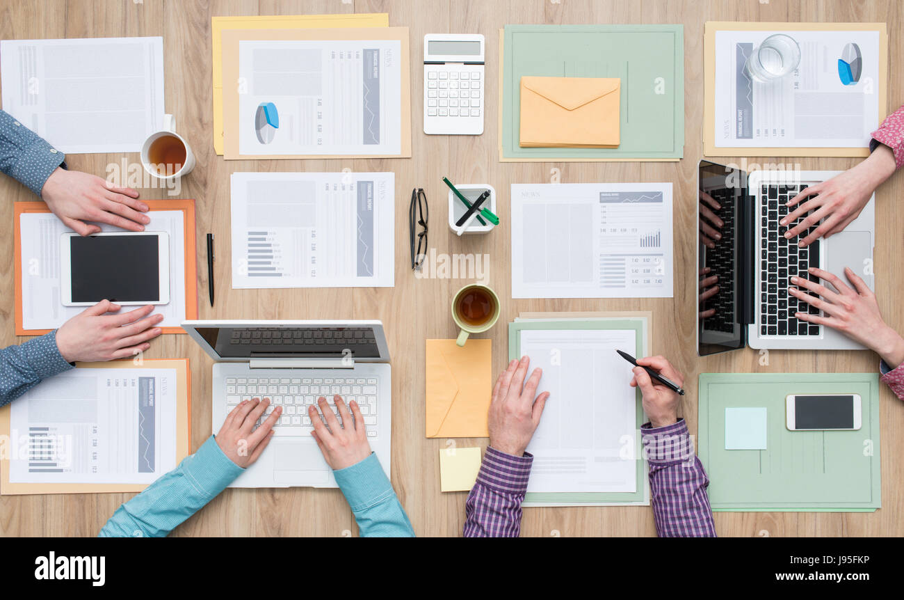 Coworkers and business team working together at office desk ...