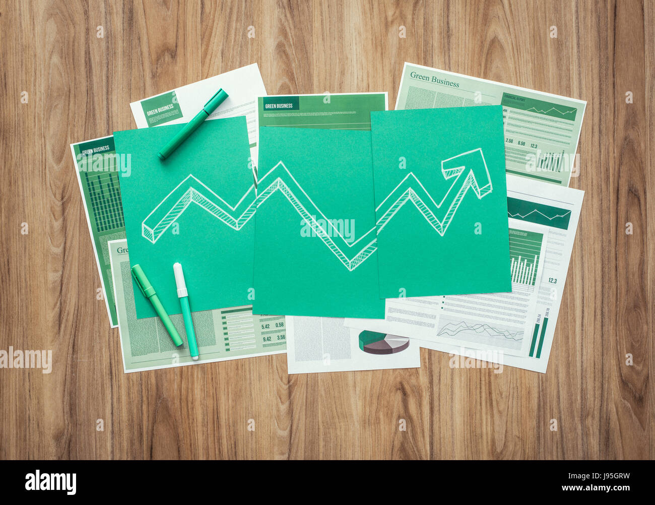 Hand drawn chart with arrow on green sheets and paperwork, green ...