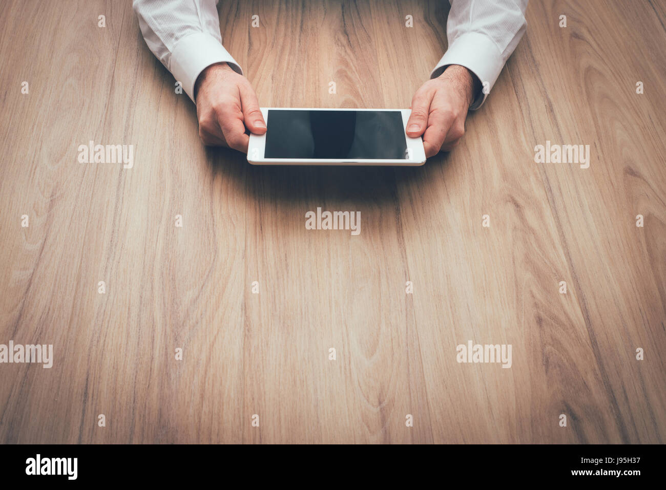 Businessman working at office desk and using a digital touch screen ...