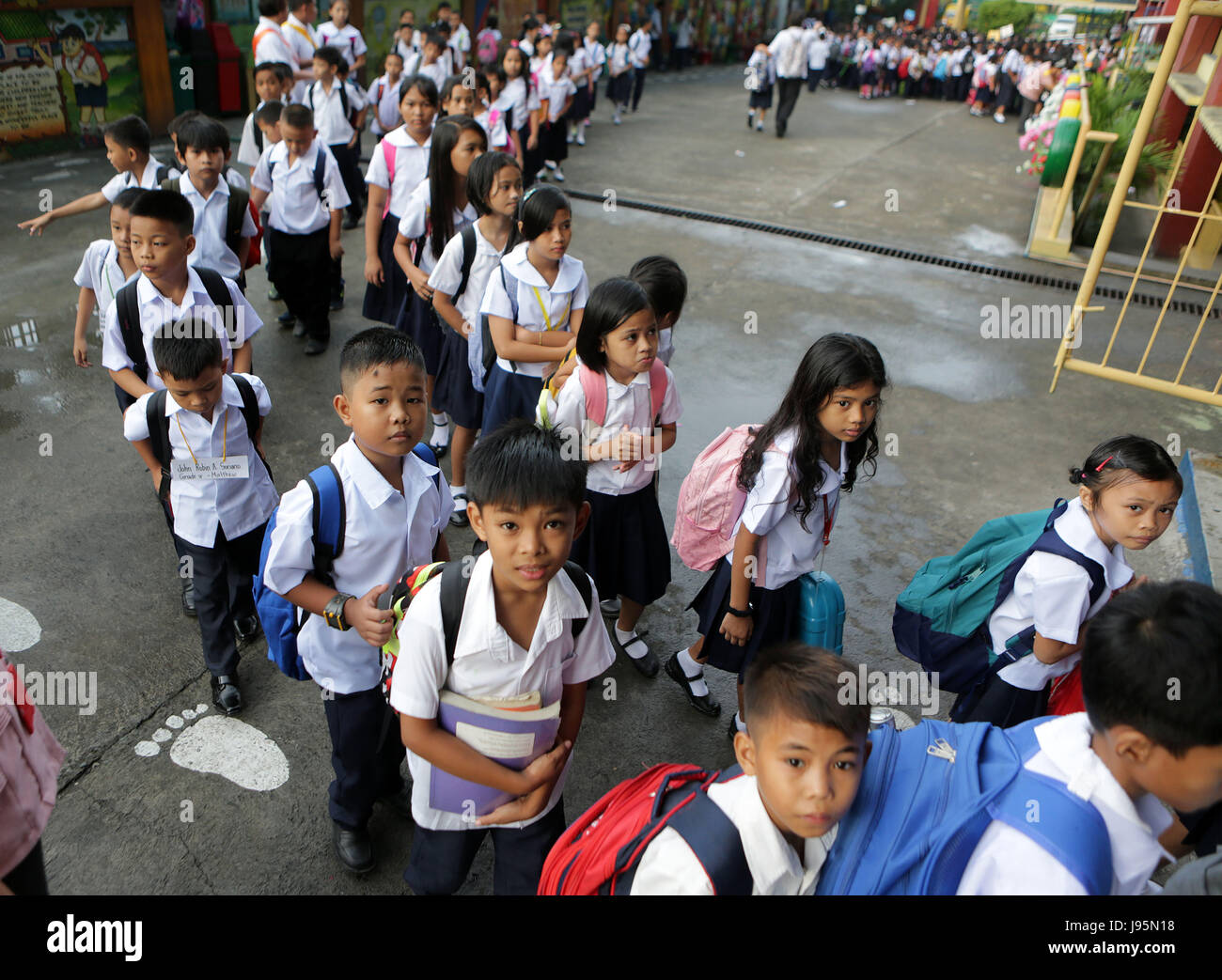Quezon City, Philippines. 5th June, 2017. Students line up as they walk to their classrooms ...