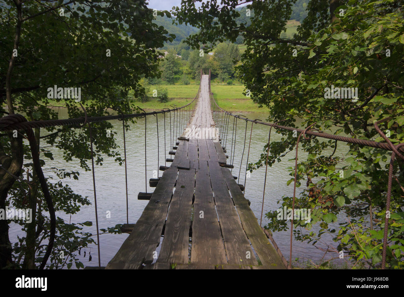 old wooden cable bridge over the mountain river Stock Photo - Alamy