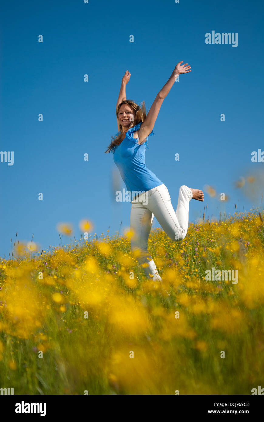 young woman in the spring in the meadow jumping Stock Photo - Alamy