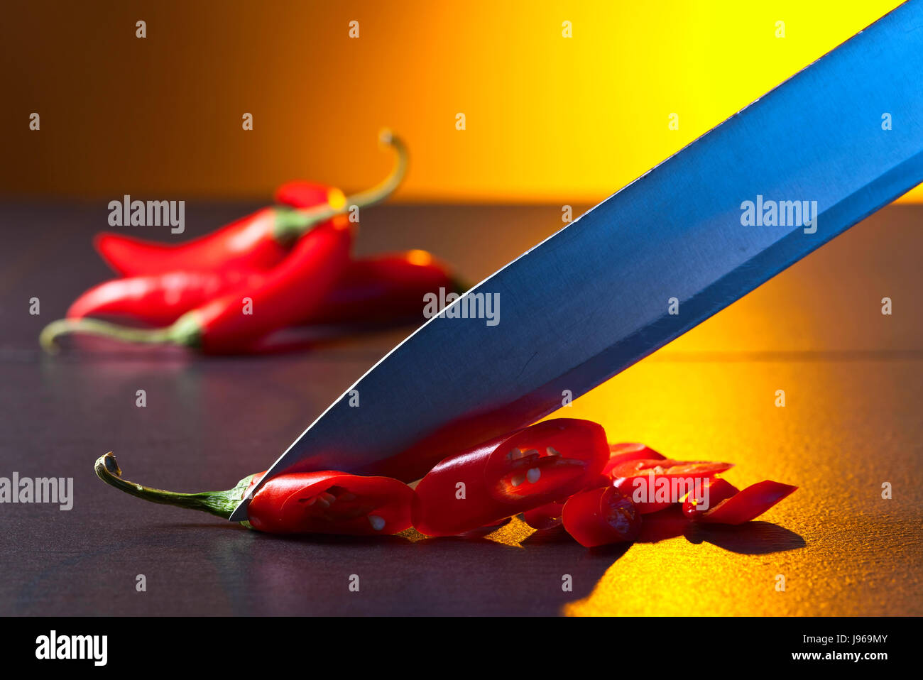 Knife and red chilli pepper on black table Stock Photo - Alamy