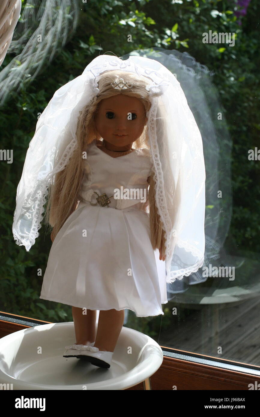 American Girl doll dressed in a communion dress with a white veil and white shoes Stock Photo Alamy
