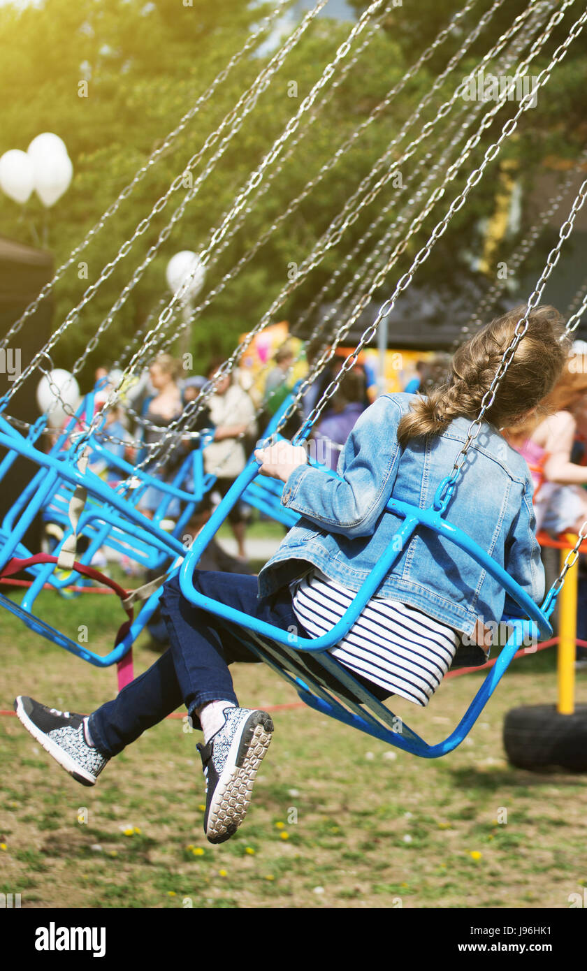 Little girl is riding a carousel in amusement park Stock Photo - Alamy