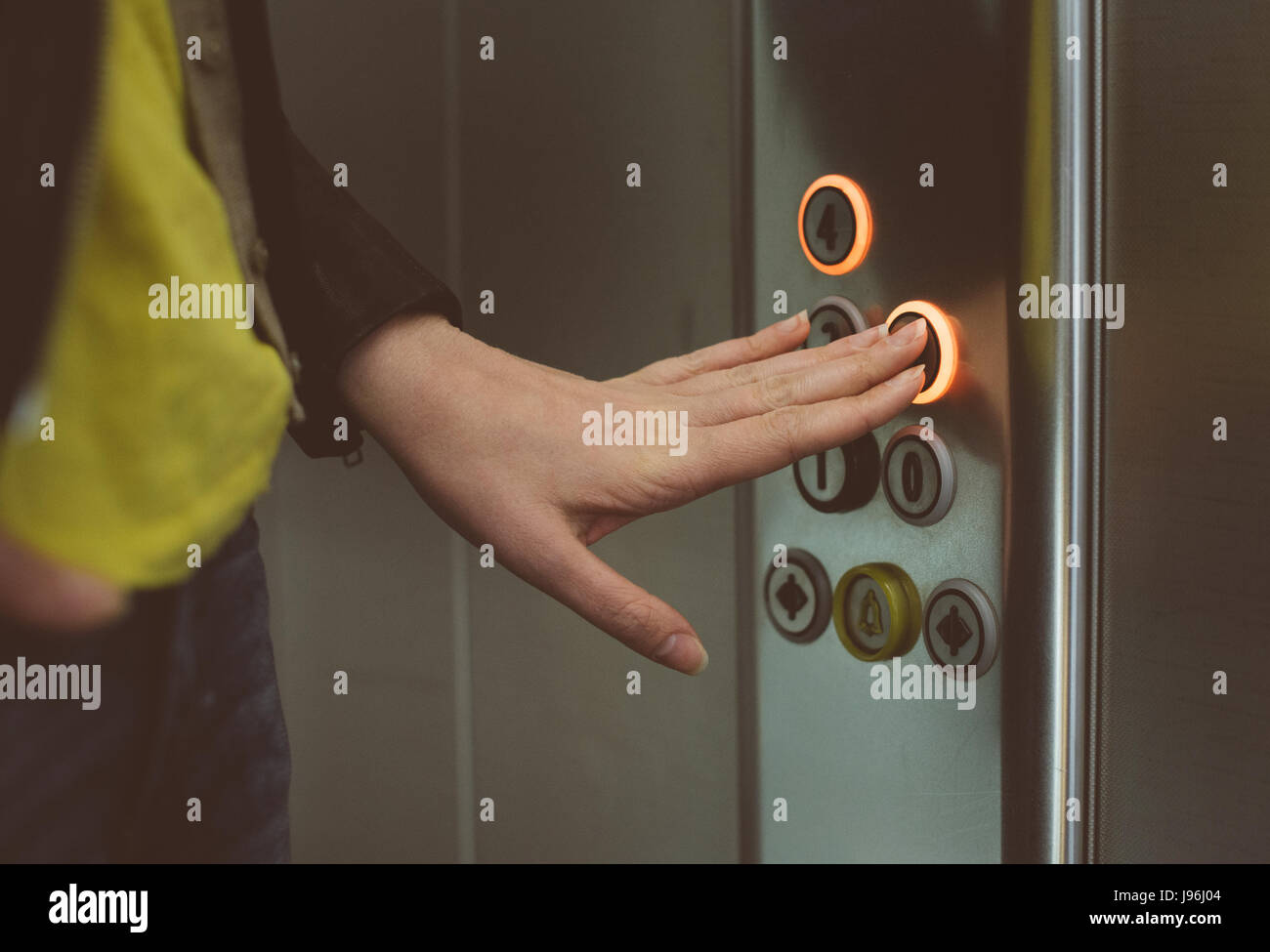 Woman pressing button inside elevator Stock Photo - Alamy