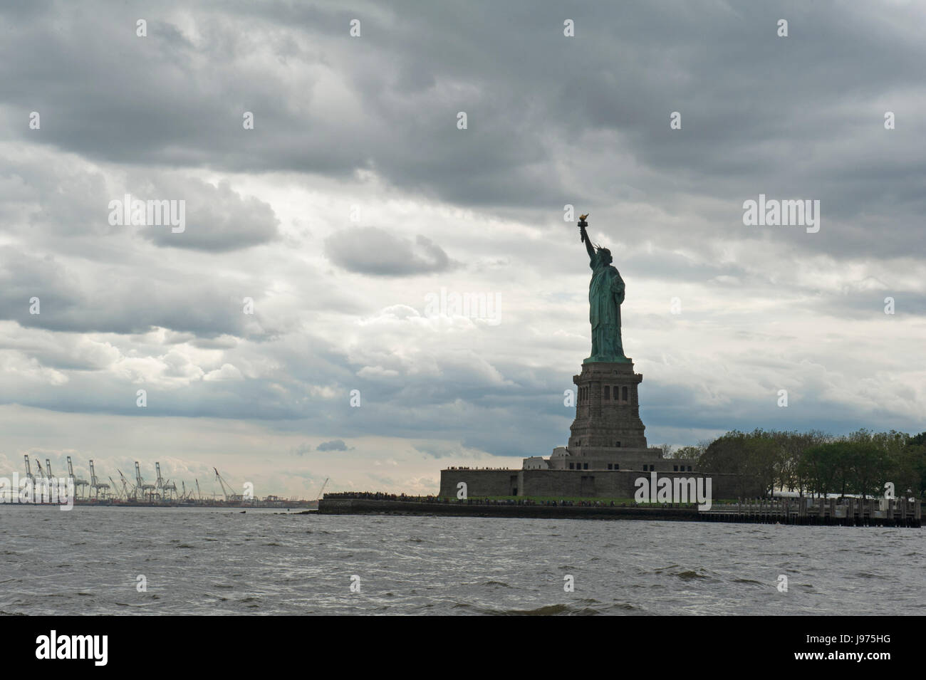 The Statue of Liberty on Liberty Island in New York Harbor on a cloudy ...