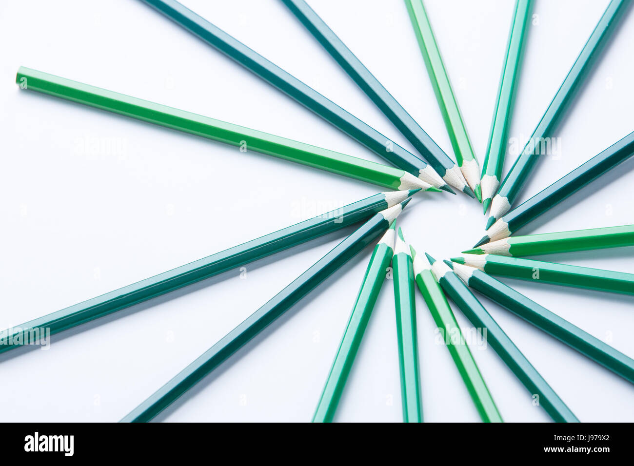 green pencils arranged in a circle on thr right side on light ...
