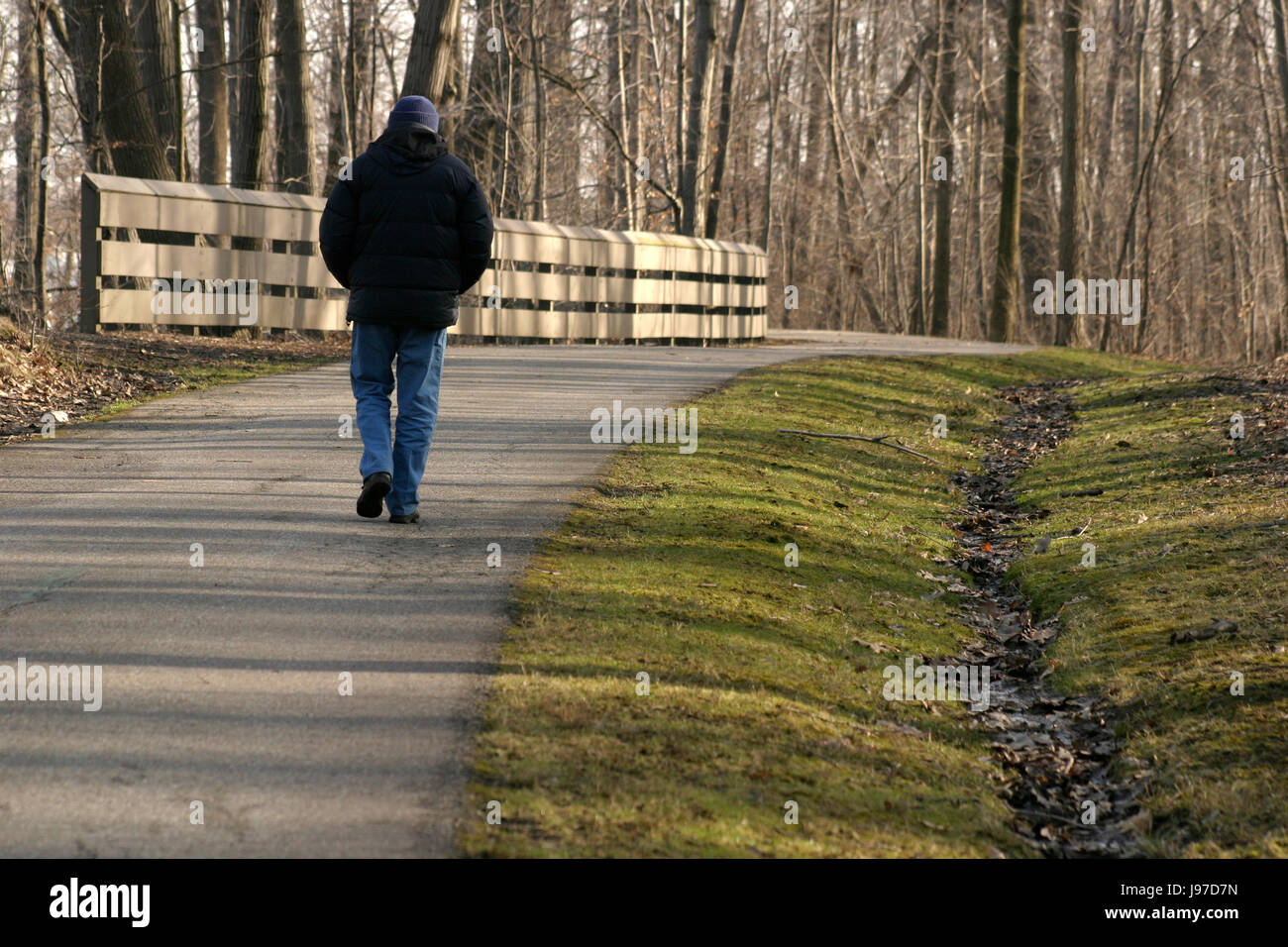 Man walking alone on park's trail Stock Photo - Alamy