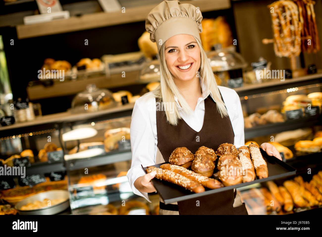 Beautiful female bakery posing with various types of pastries and ...