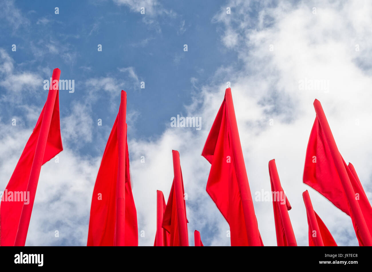 Group of red flags on blye sky background Stock Photo - Alamy