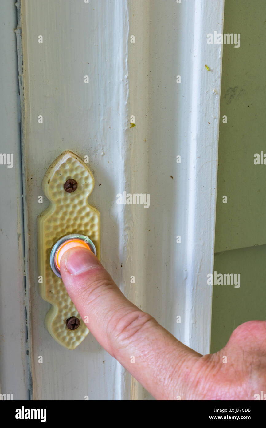 Male finger preparing to ring a doorbell to a front door with a white ...