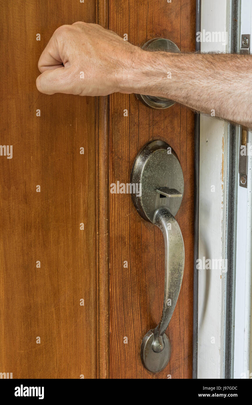 Male hand knocking on a wooden door with door handle in the shot Stock ...