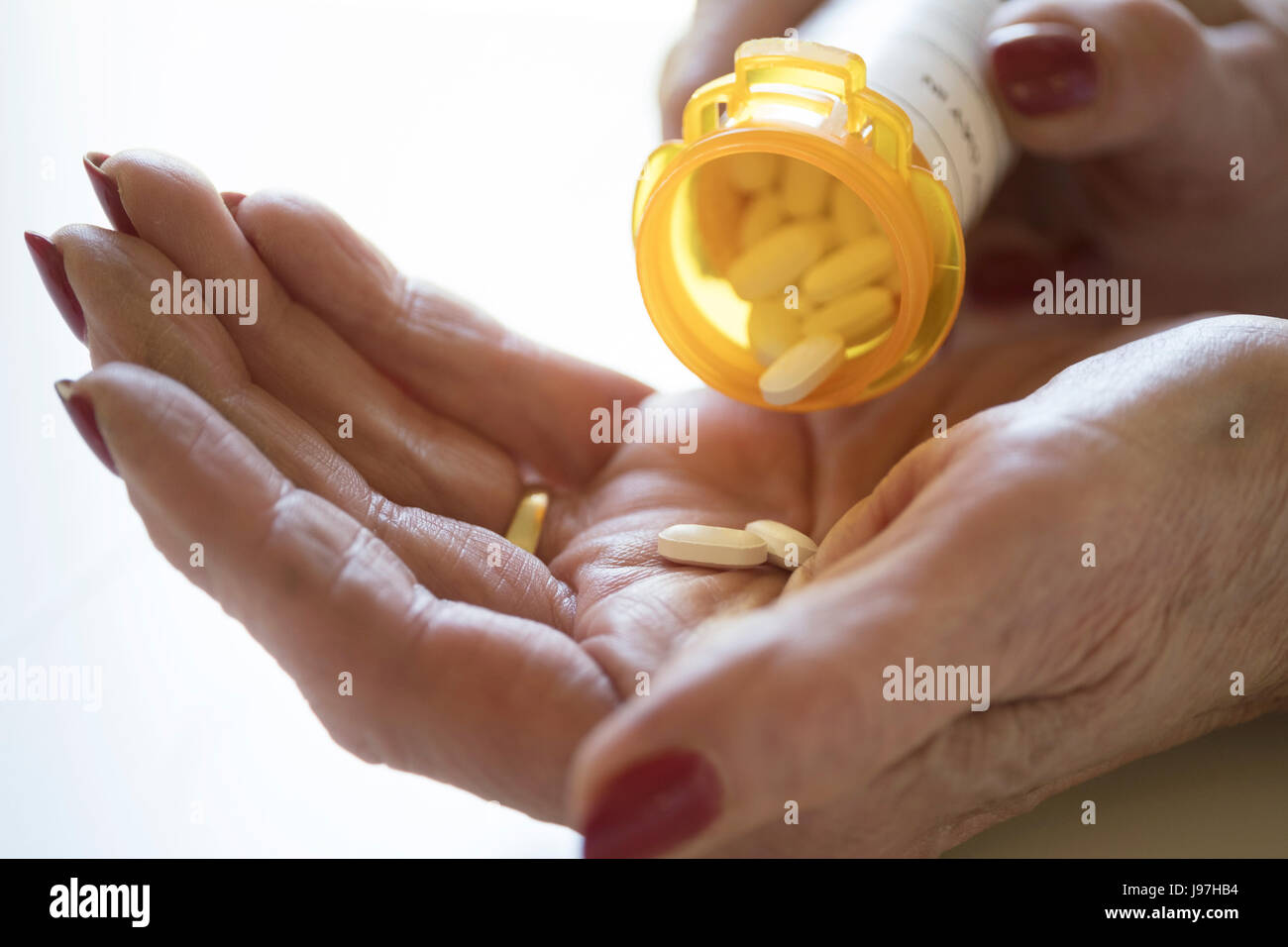 Female hand holding pill bottle Stock Photo - Alamy