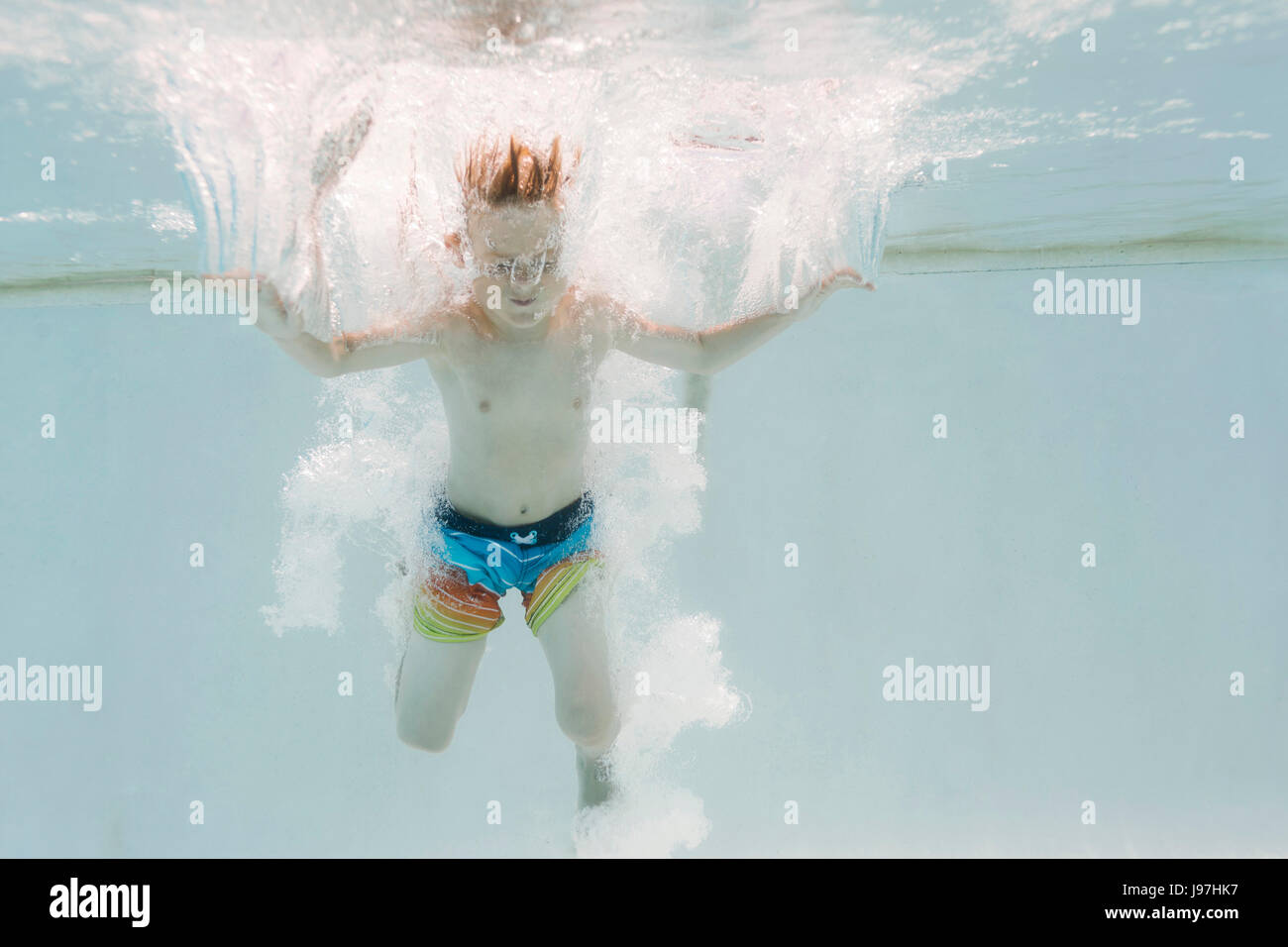 Boy (6-7) jumping into swimming pool Stock Photo - Alamy