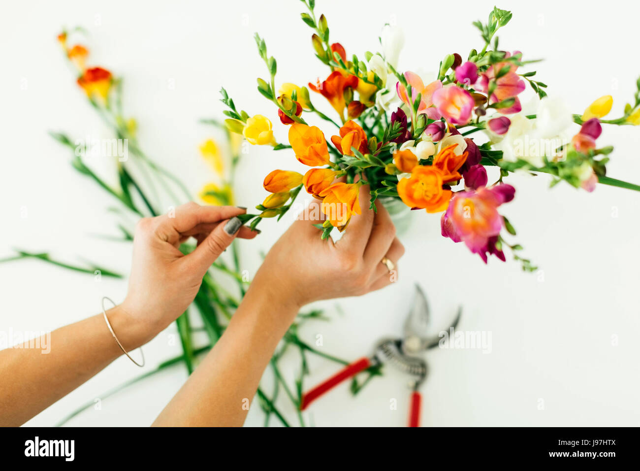 Woman putting flowers into jar Stock Photo - Alamy