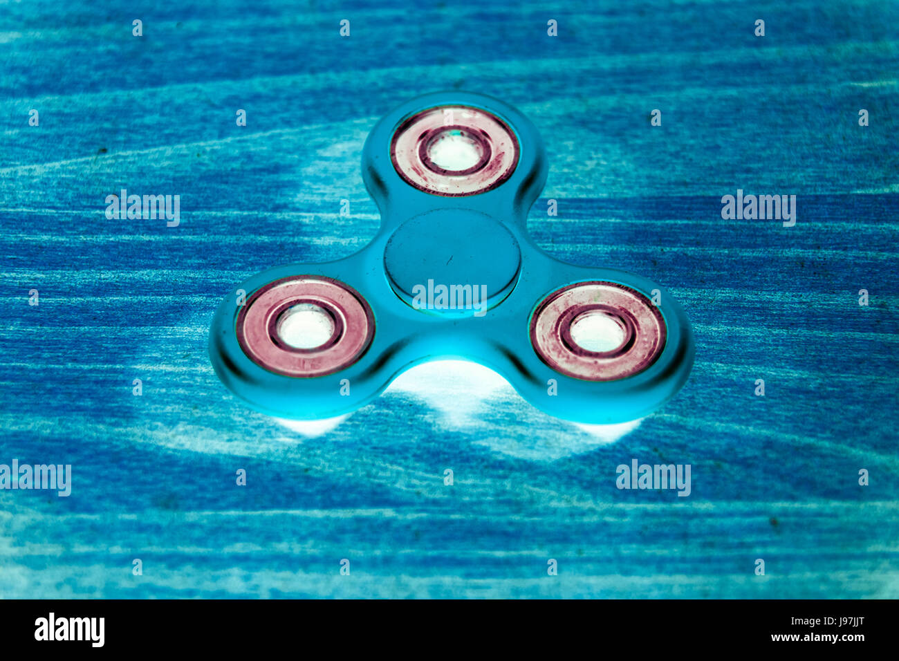 Fidget Spinner in fluorescent UV glowing isolated background for stress ...