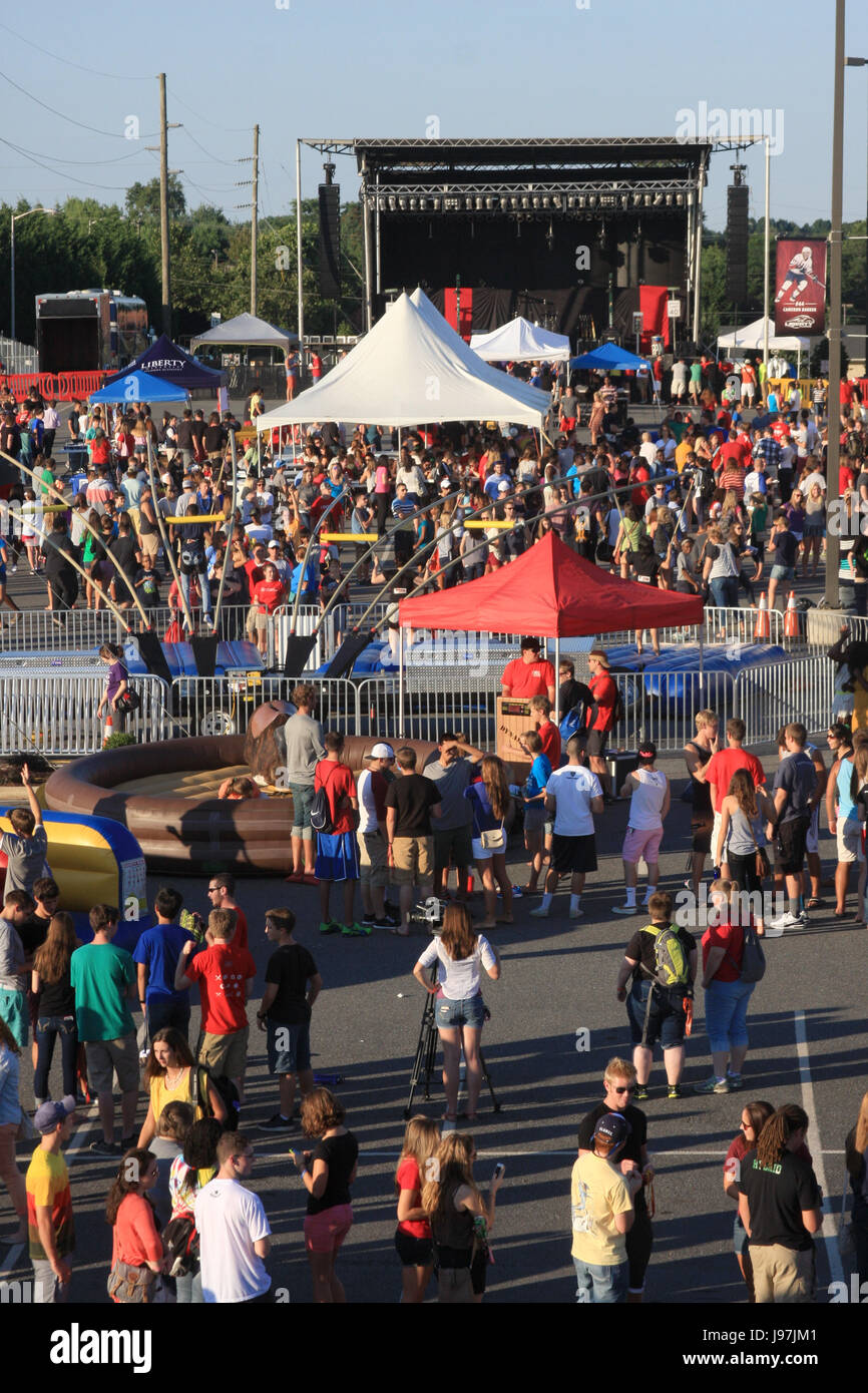 Crowd on entertainment grounds, with rides and inflatables Stock Photo ...