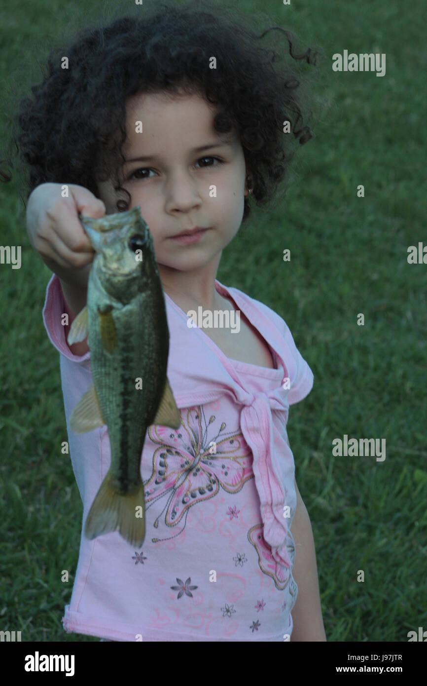 Little cute girl holding fish by mouth Stock Photo - Alamy
