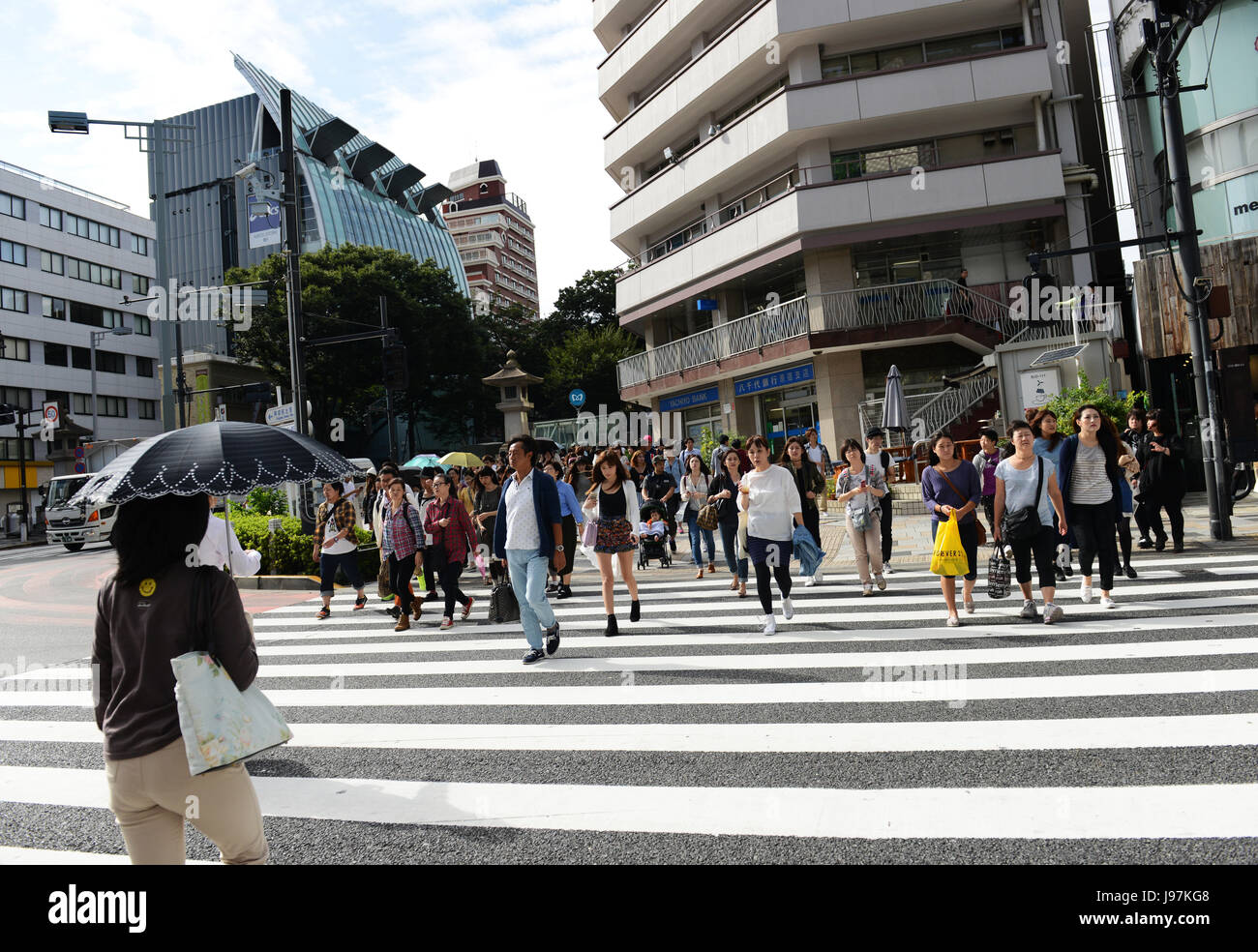 Pedestrians crossing the fashionable Omotesando street in central Tokyo ...