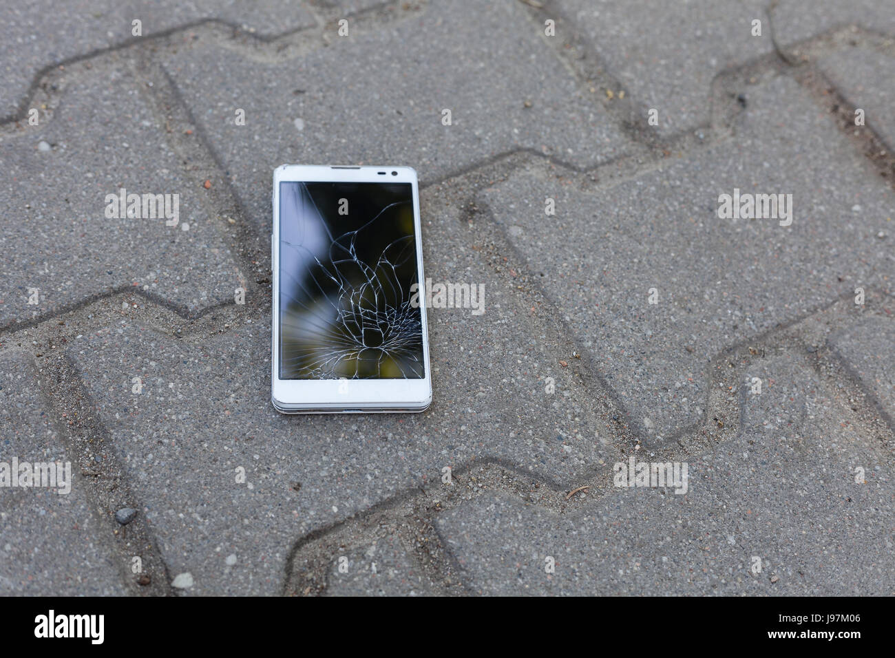 Phone with broken screen lying on the pavement Stock Photo - Alamy