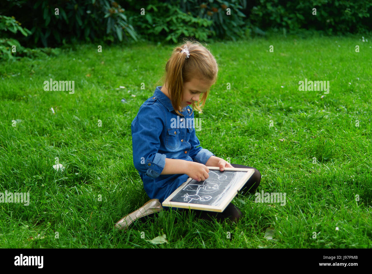 A girl drawing while on grass Stock Photo - Alamy