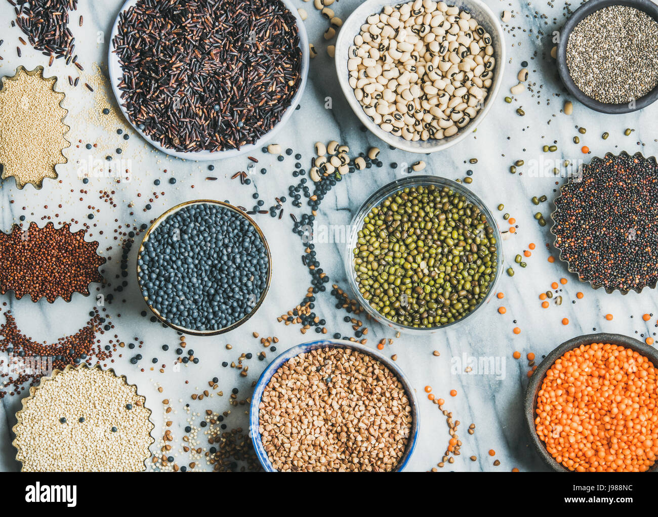 Various raw uncooked grains, beans, cereals, marble background, top ...