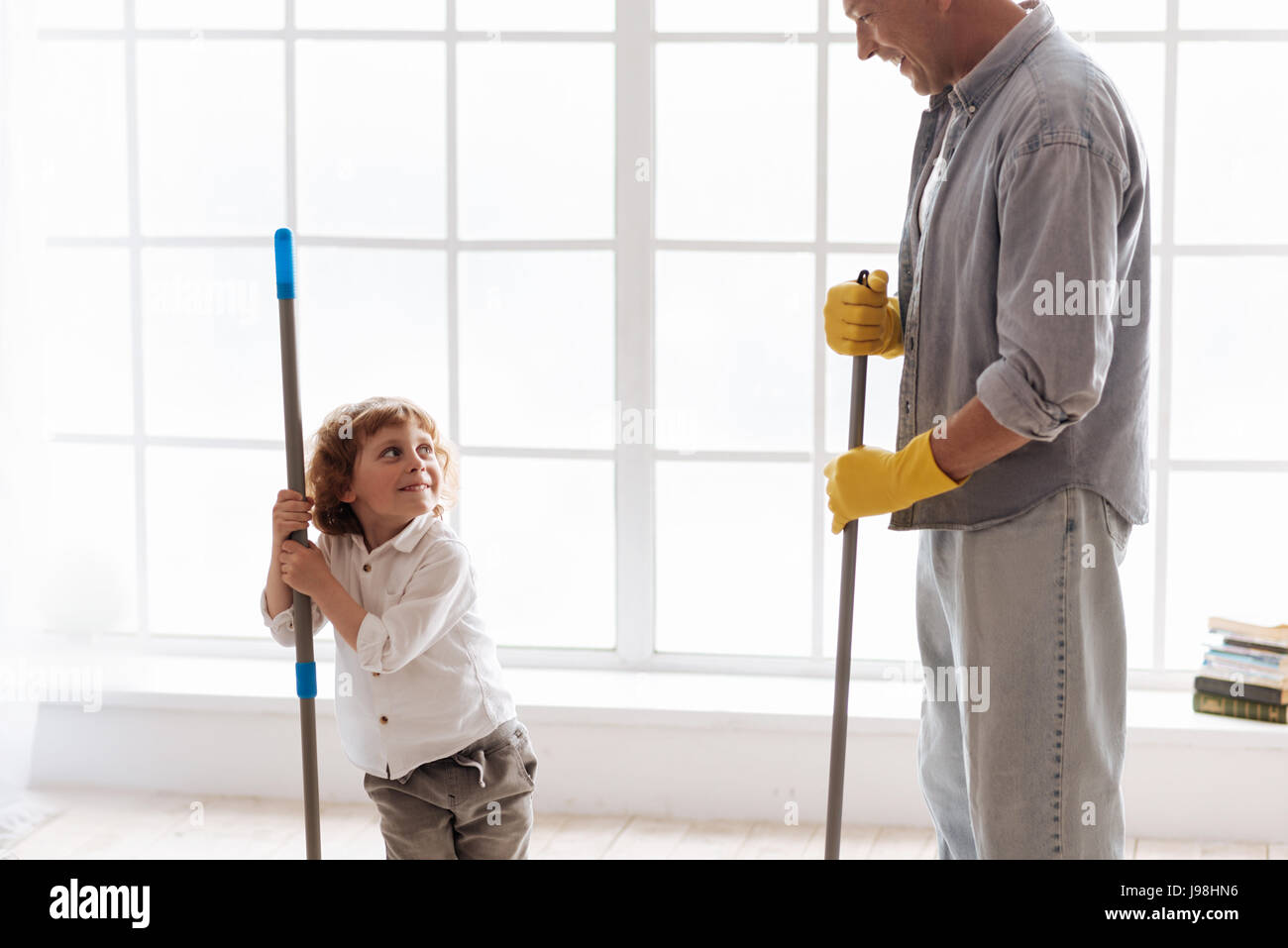 Positive tall man standing opposite his child Stock Photo - Alamy