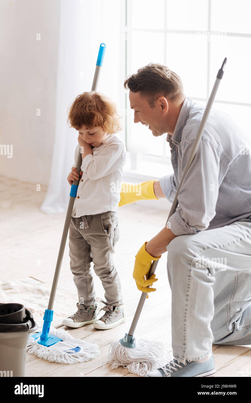 Vertical photo of father and son while holding mops Stock Photo - Alamy