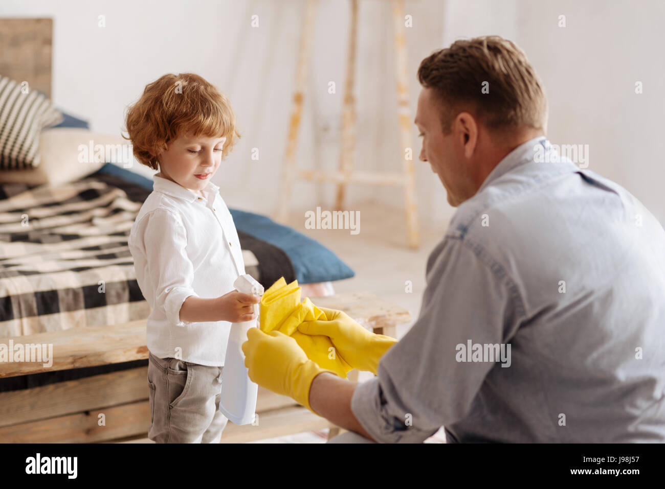 Attentive kid adding some cleaning fluid Stock Photo - Alamy