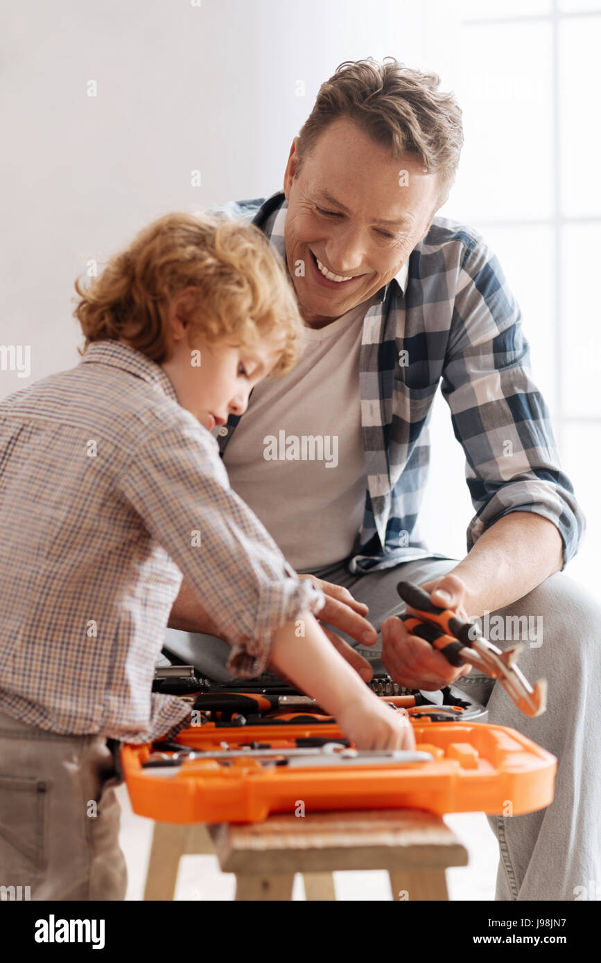 Very attentive man child choosing necessary instrument Stock Photo - Alamy