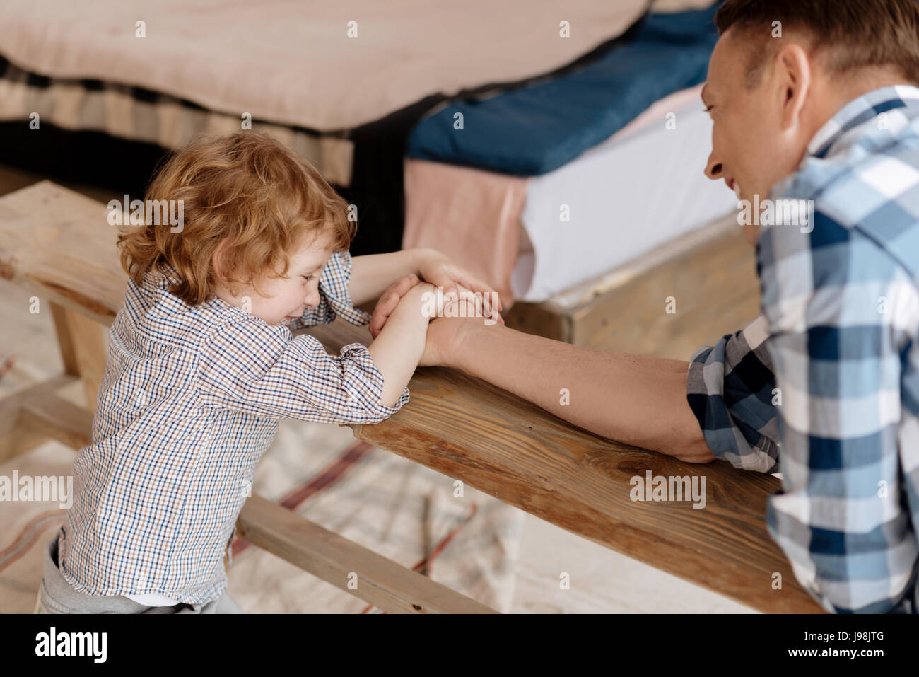 Smiling man giving himself up while playing with son Stock Photo - Alamy