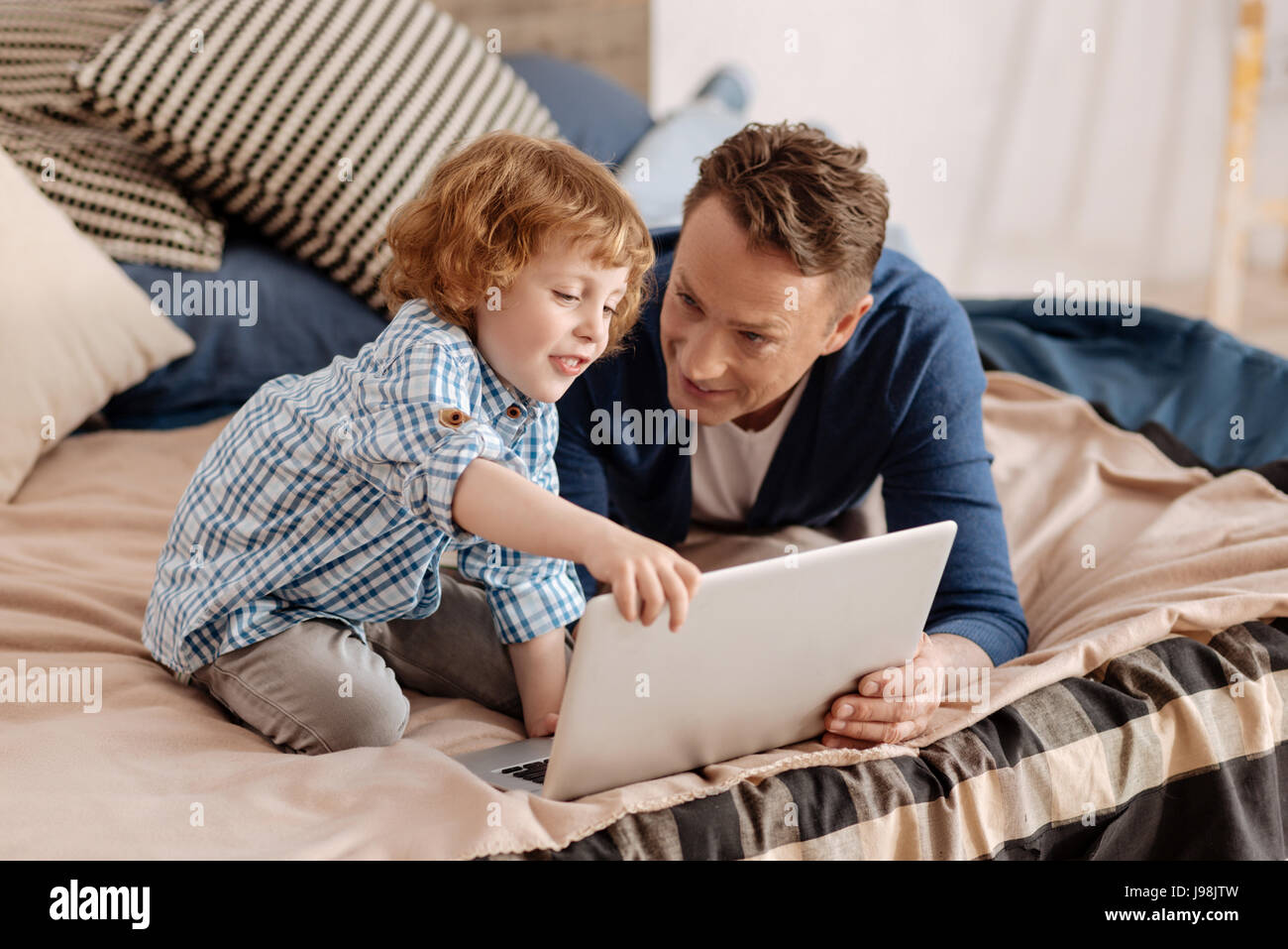 Little boy touching laptop of his father Stock Photo - Alamy