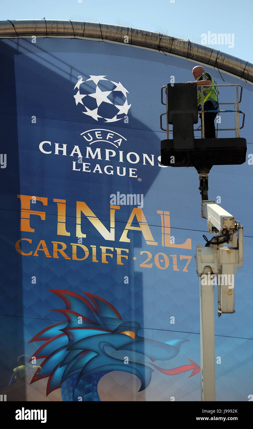 Workers secure a giant UEFA Champions League banner outside the Library ...