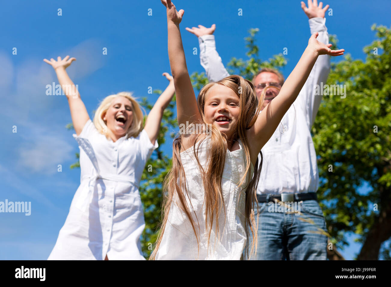 happy family outdoors jumping high Stock Photo - Alamy