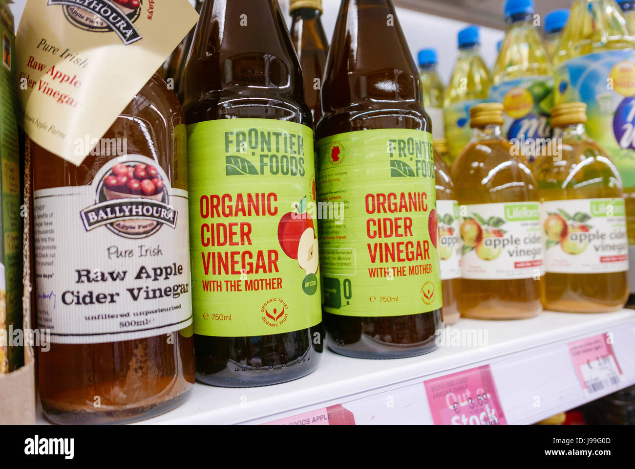 Bottles of organic apple cider vinegar on a supermarket shelf. They are ...