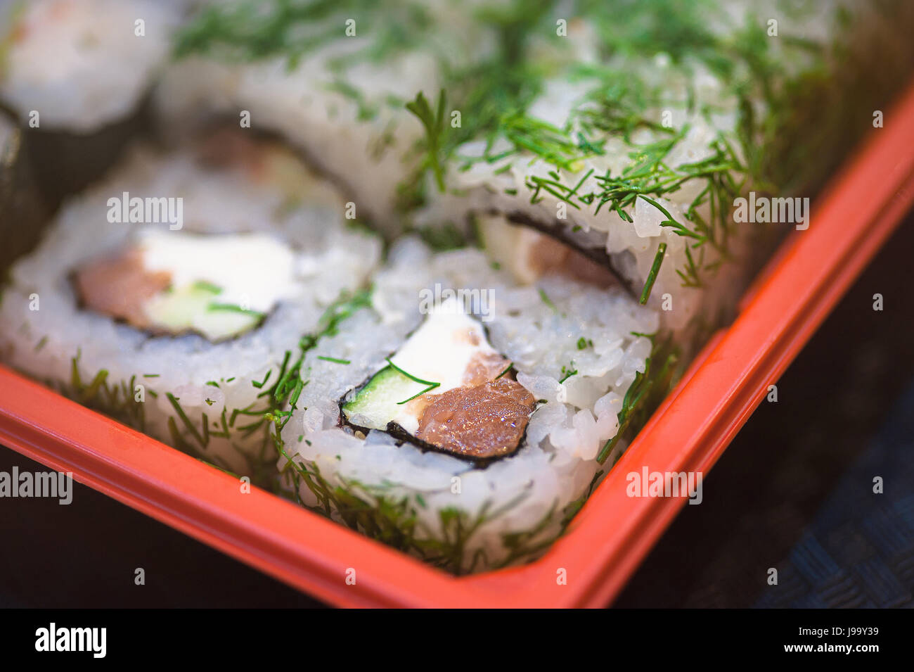 Set salmon rolls in a plastic plate on a black background Stock Photo ...