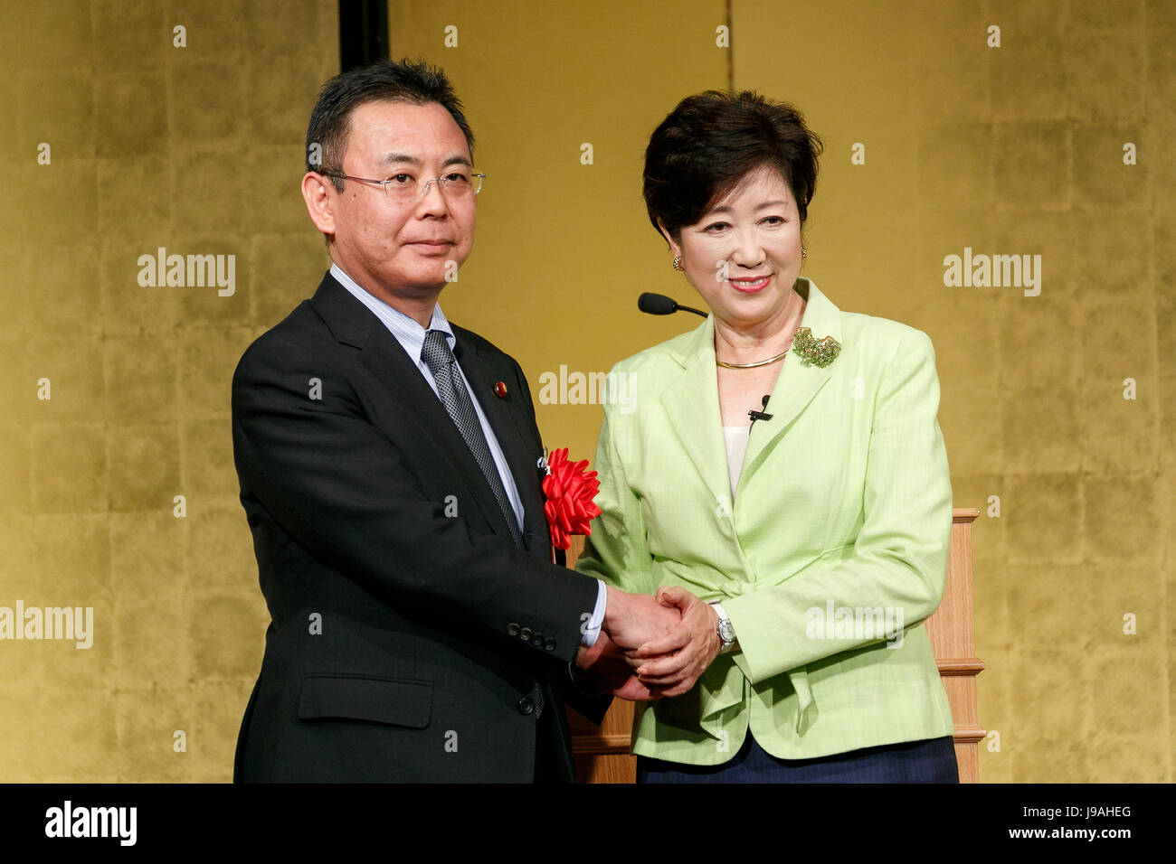 Tokyo Governor Yuriko Koike (R) shakes hands with New Komeito Party lawmaker Yosuke Takagi (L ...