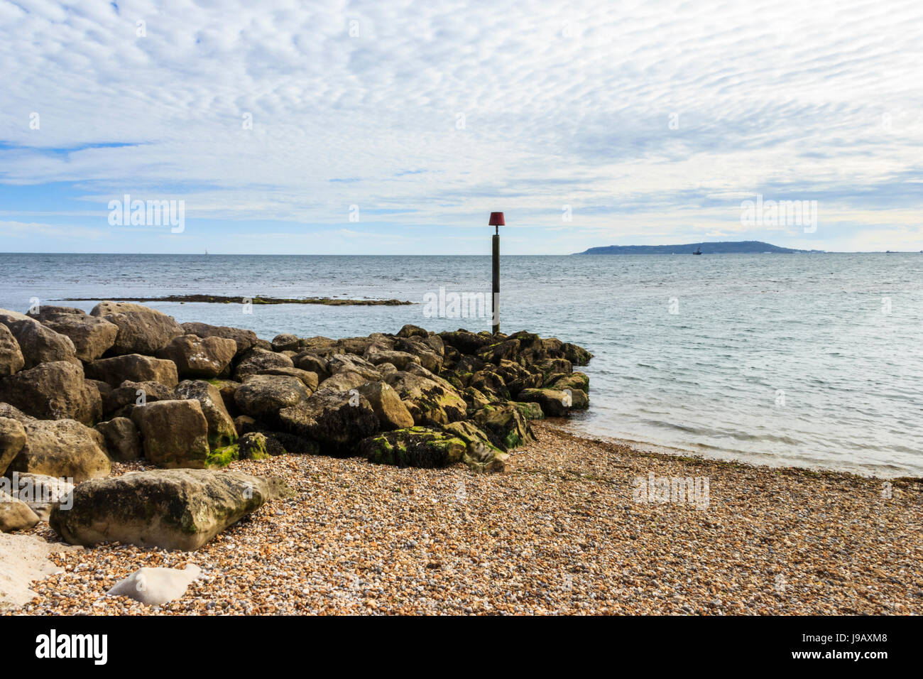 Warning post on a rocky promontory at Ringstead Bay, Dorset, England ...