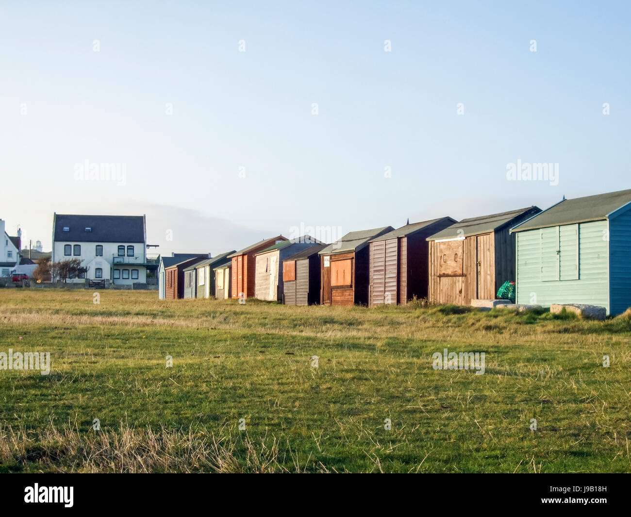 Evening sun on wooden beach huts by the coast path at Portland Bill ...