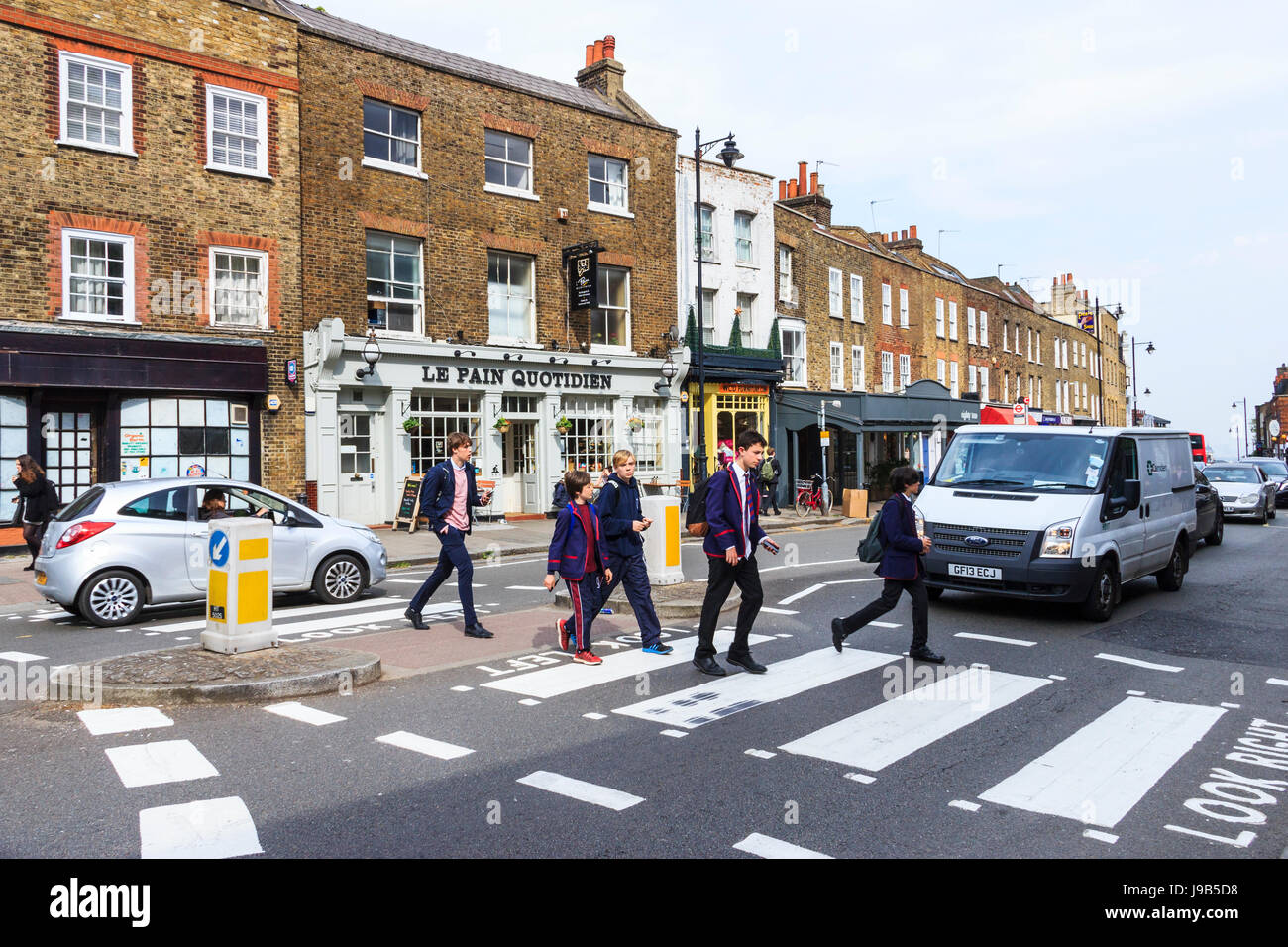 Schoolchildren crossing the road on a zebra pedestrian crossing in ...