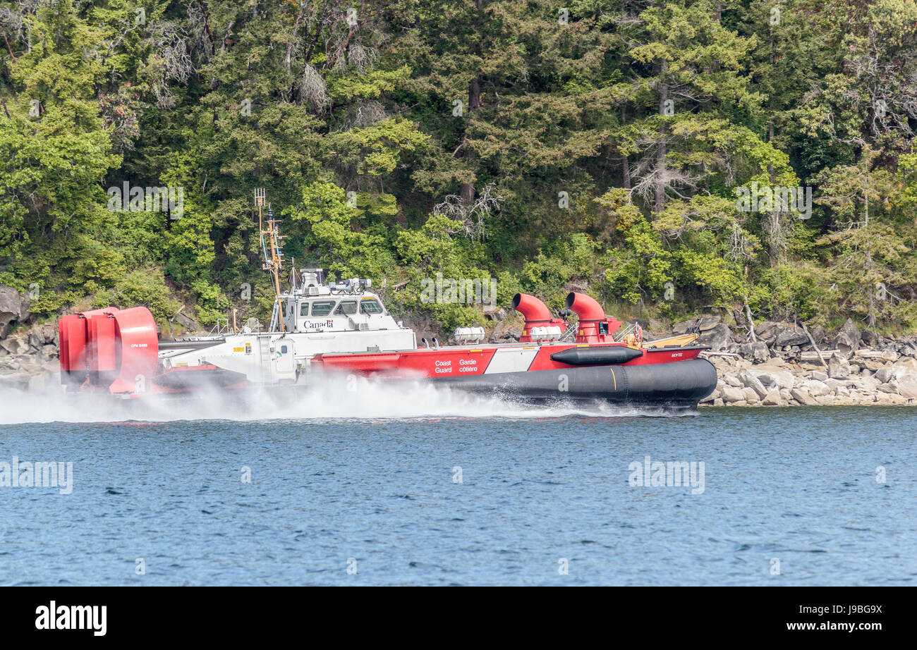 A Canadian Coast Guard hovercraft speeds alongside the shoreline of ...